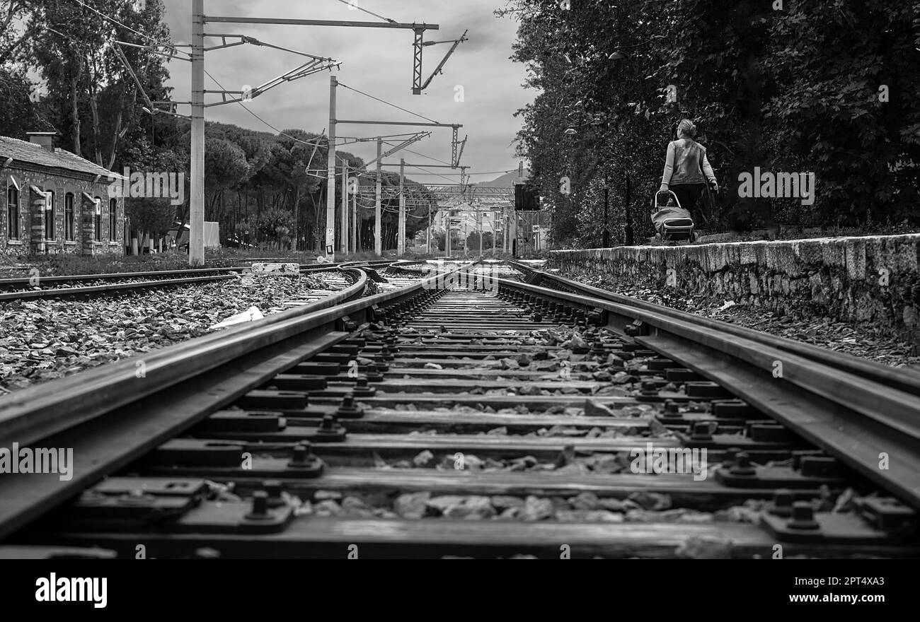 woman walking by train tracks at the train station Stock Photo - Alamy