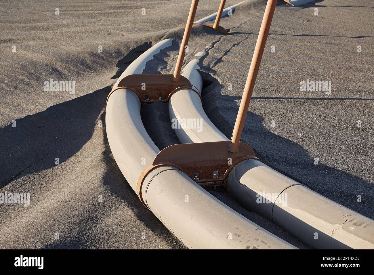 Pipes lying in the black sand of Iceland Stock Photo - Alamy