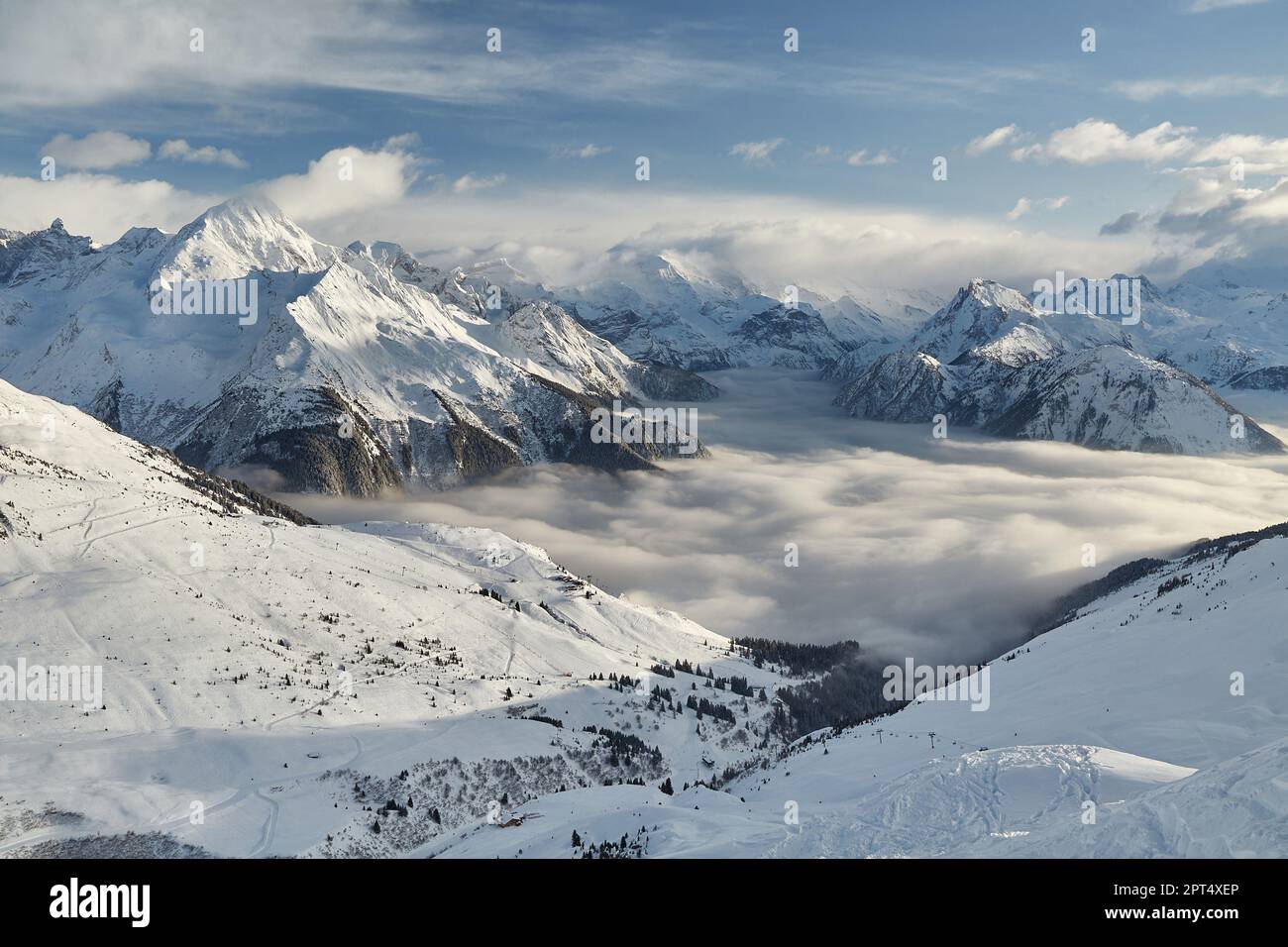 Snowy high mountains scenic landscape above clouds below in the valley ...