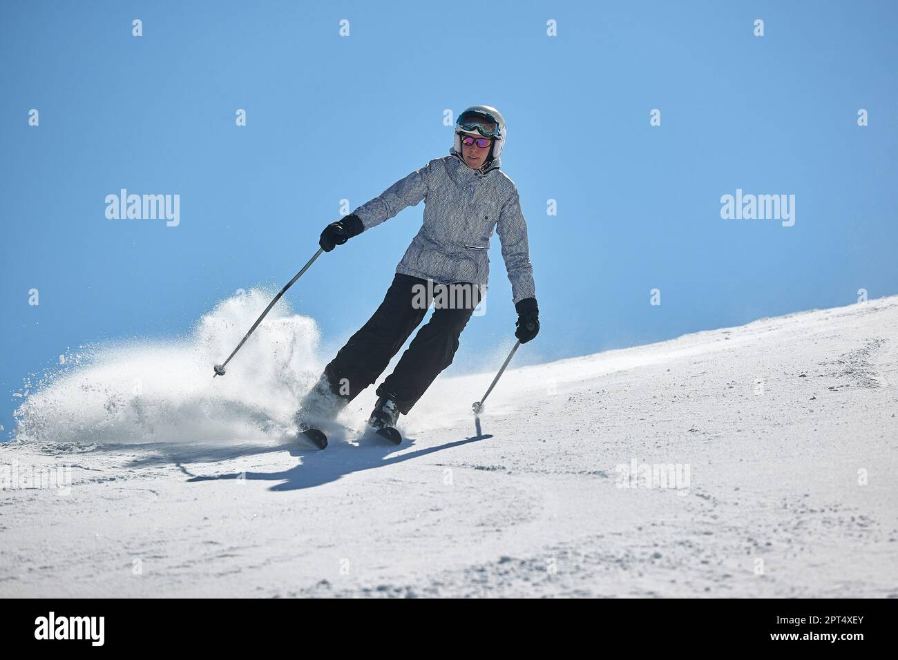 Skier sliding down a snowy slope fast Stock Photo - Alamy