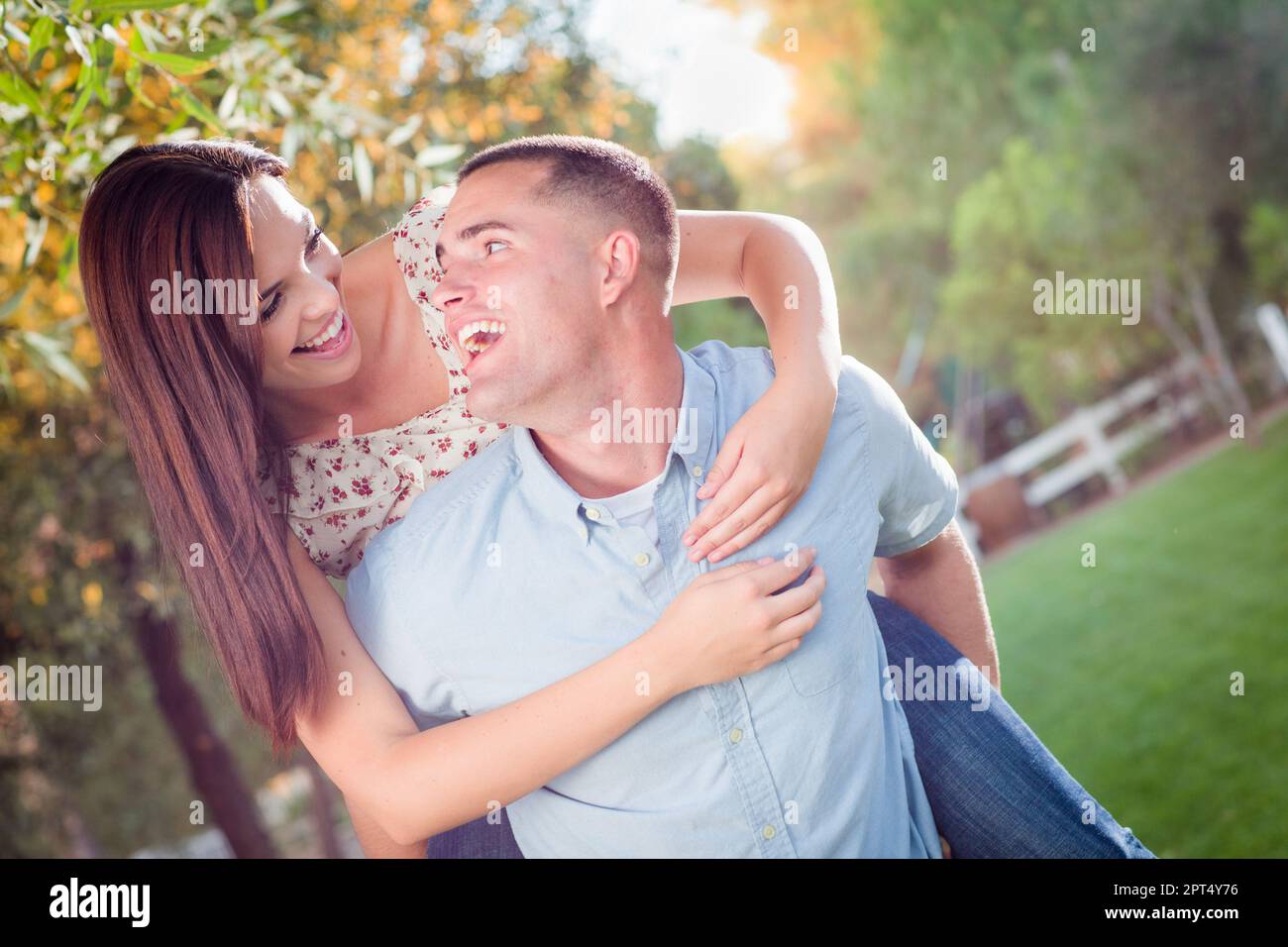 Happy Romantic Caucasian Couple Piggyback Riding in the Park Stock ...