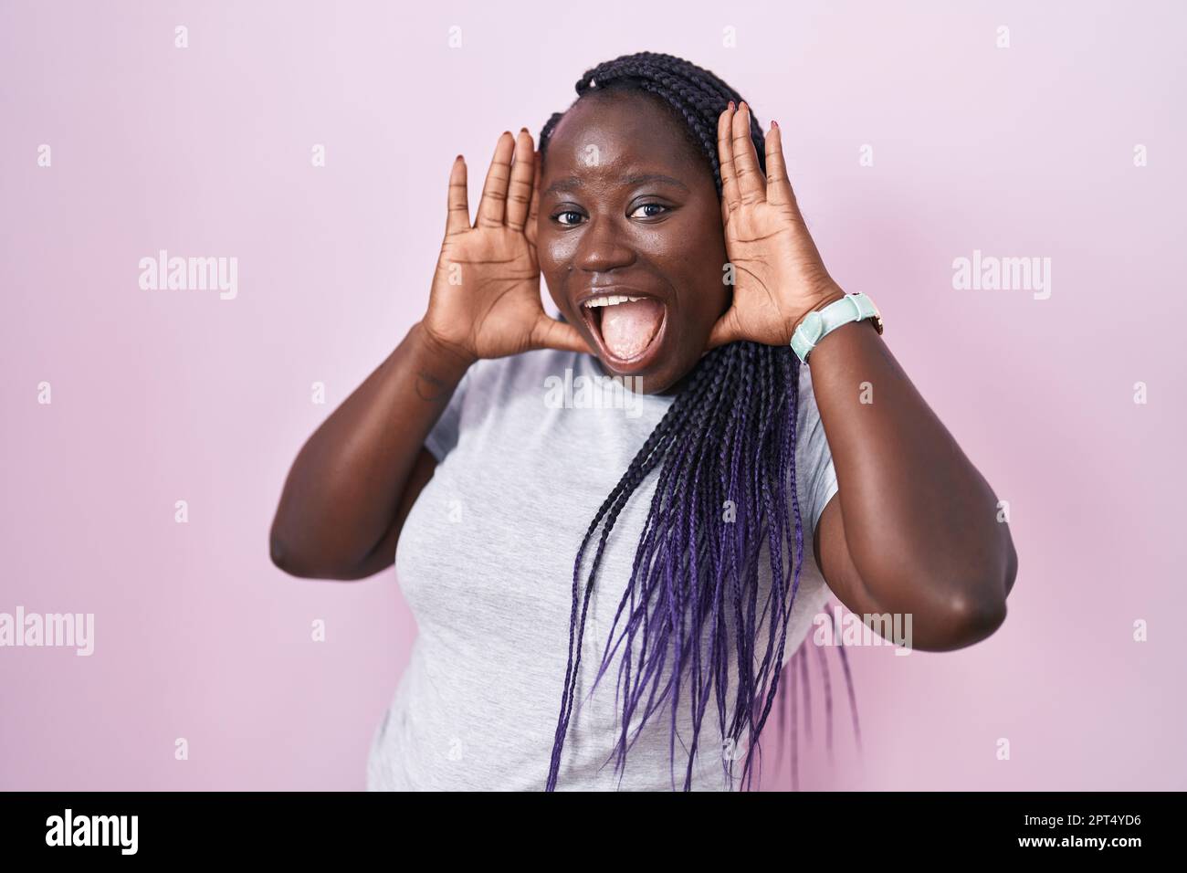 Young african woman standing over pink background smiling cheerful ...