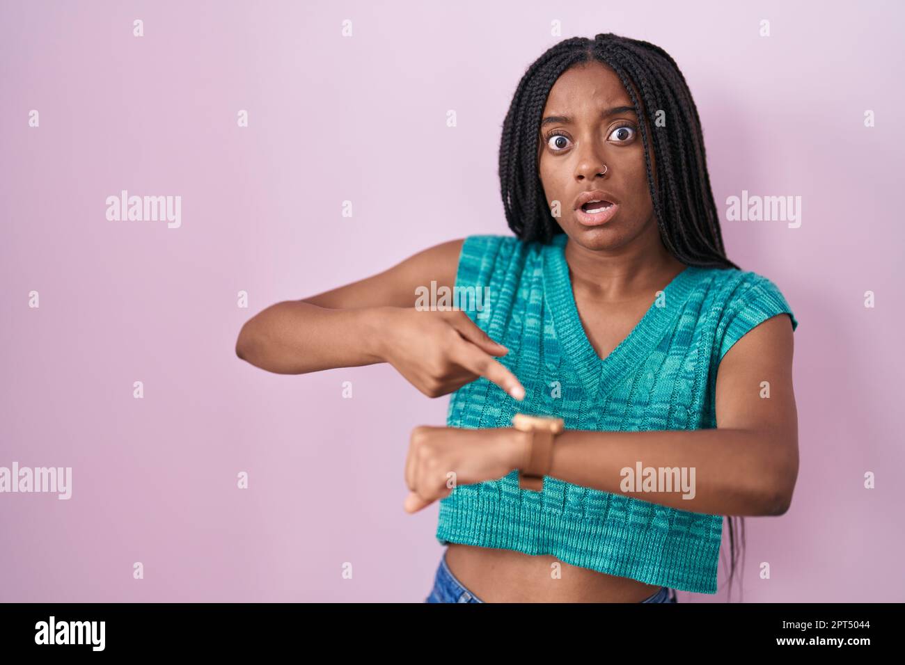 Young african american with braids standing over pink background in ...