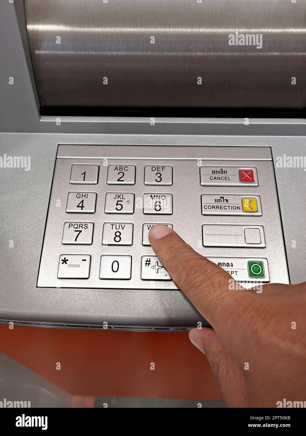 Close-up of hand entering PIN/pass code on ATM/bank machine keypad ...
