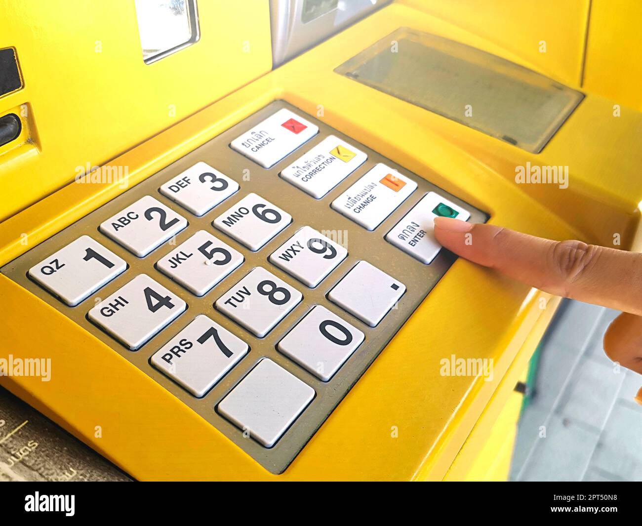Close-up of hand entering PIN/pass code on ATM/bank machine keypad ...