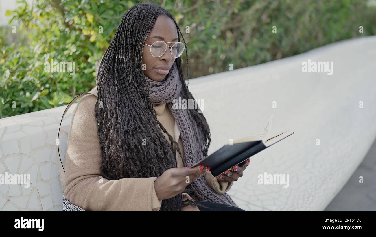 African woman reading a book at park Stock Photo - Alamy
