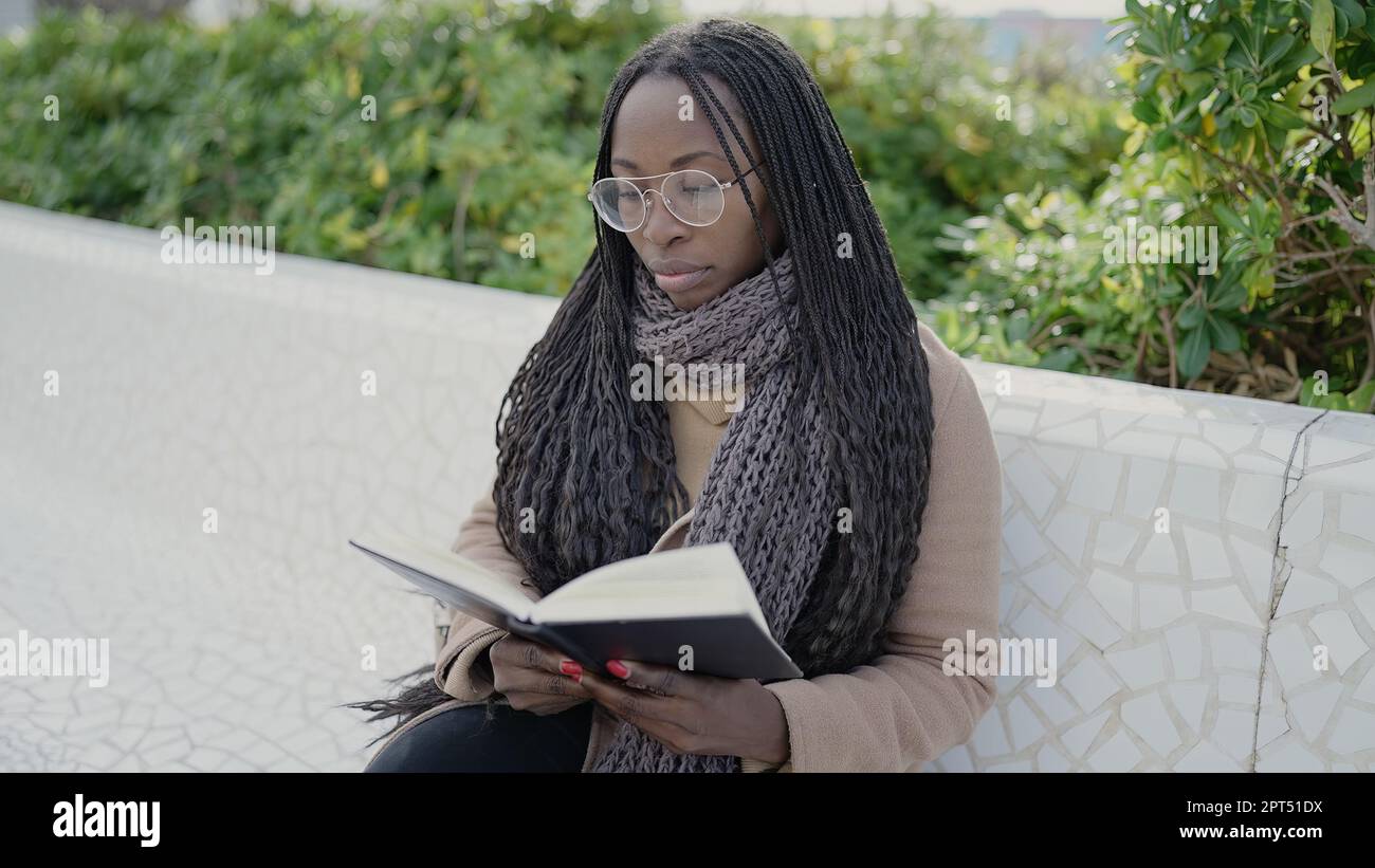 African woman reading a book at park Stock Photo - Alamy