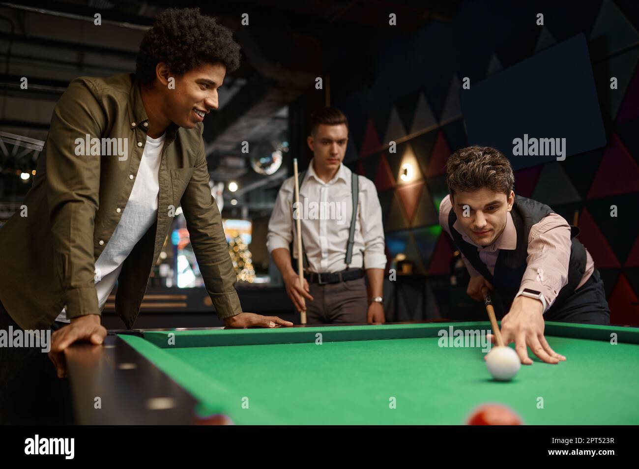 Group of happy friends enjoying billiard game, company of handsome ...