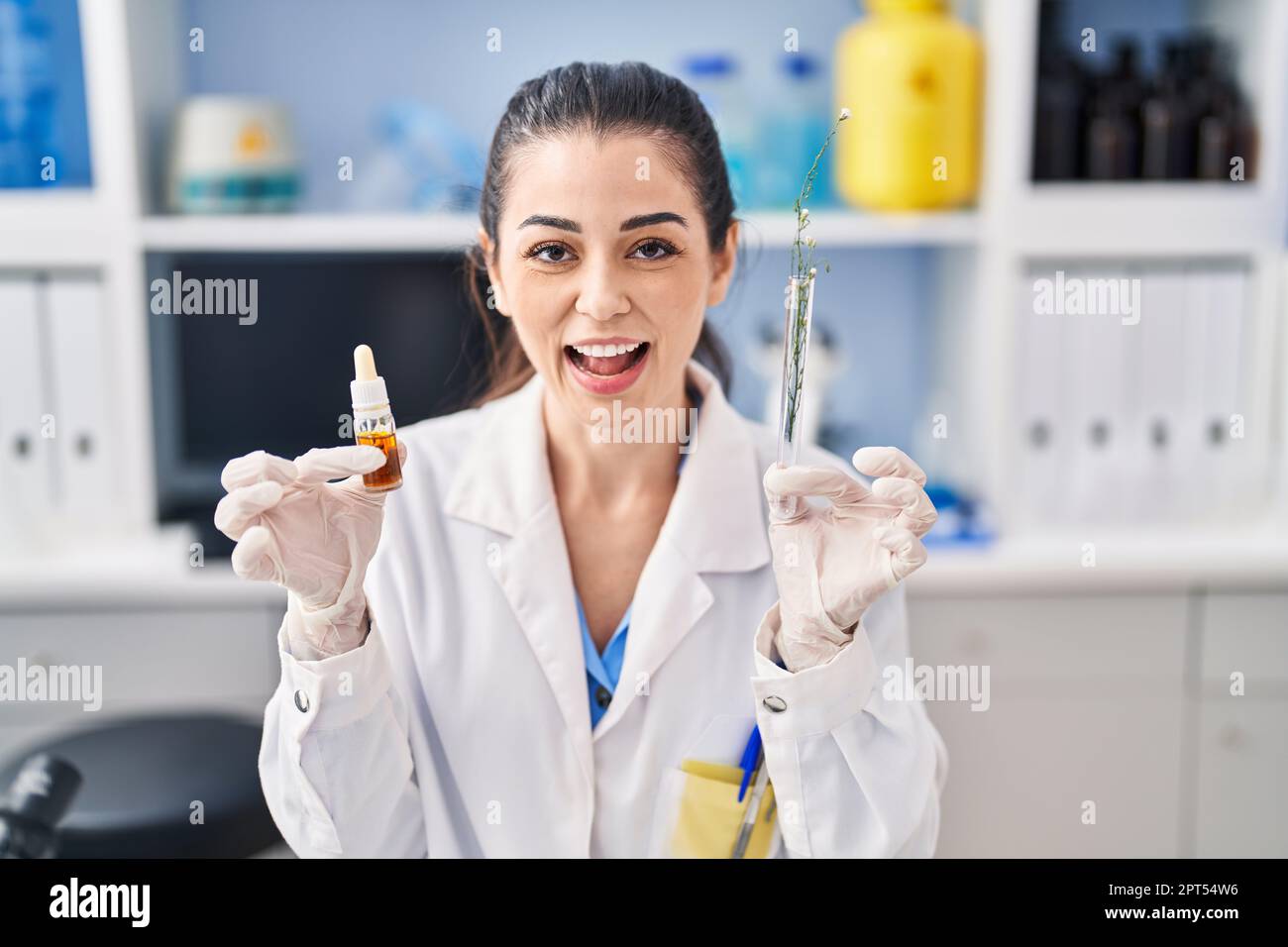 Young woman doing weed oil extraction at laboratory smiling and ...