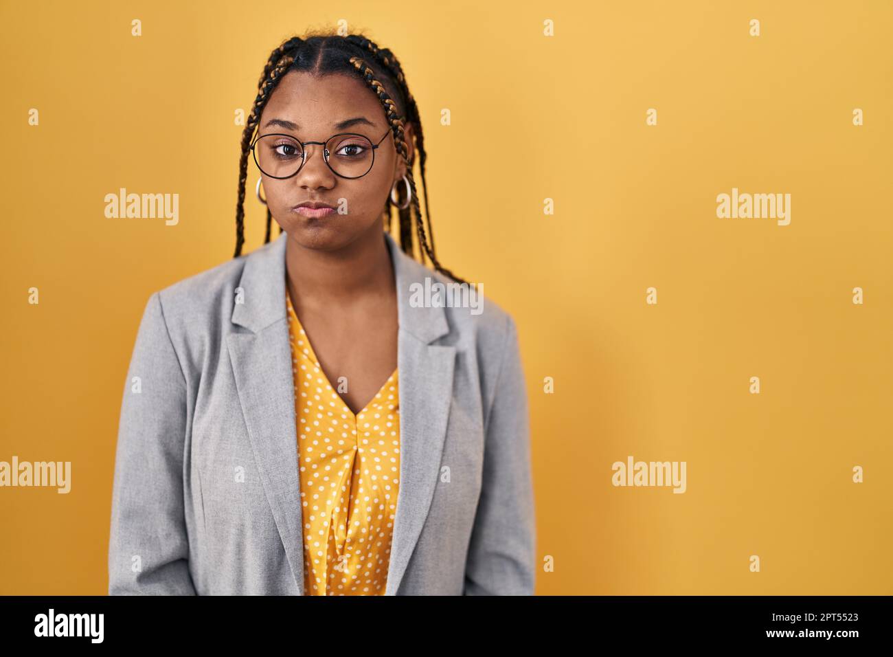 African american woman with braids standing over yellow background ...