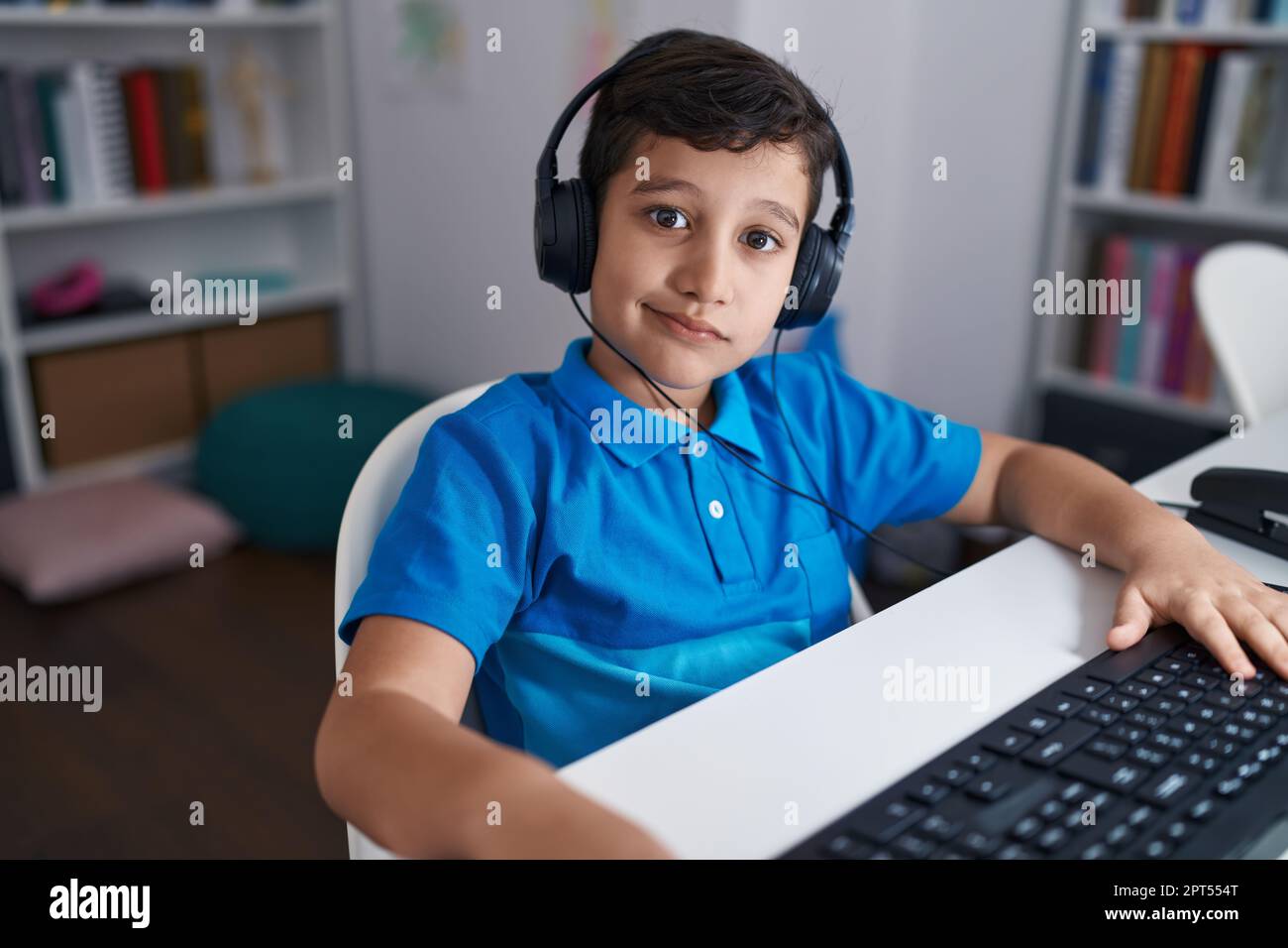 Little hispanic boy using computer laptop at the school looking ...