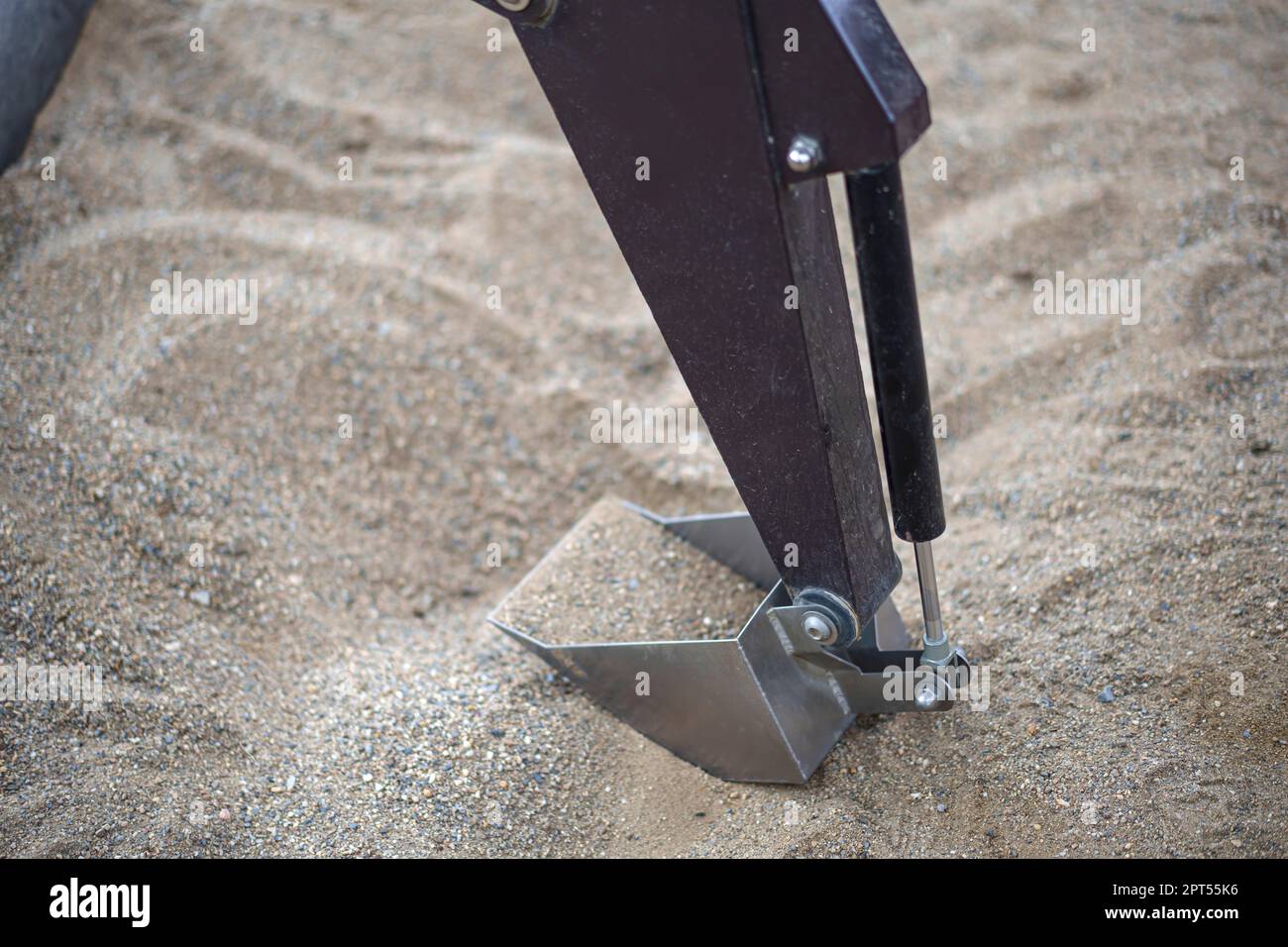 Close up shot of a mini excavator lifting some and with its cup Stock ...