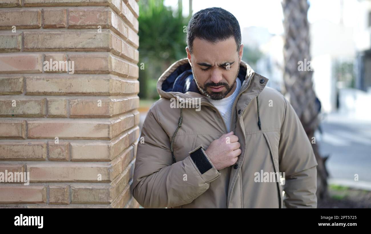 Young hispanic man suffering heart attack at street Stock Photo - Alamy