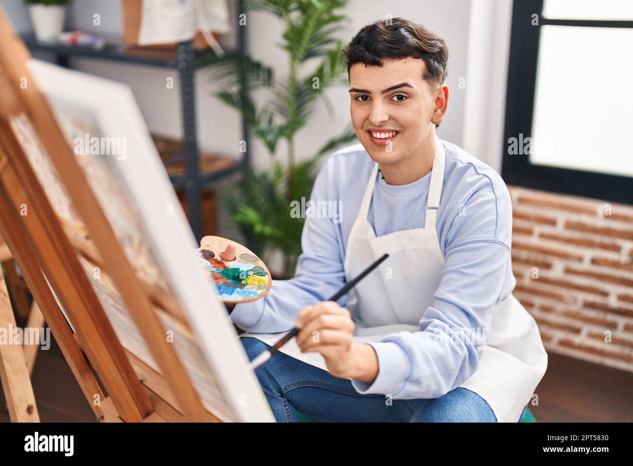 Young non binary man artist smiling confident drawing at art studio ...
