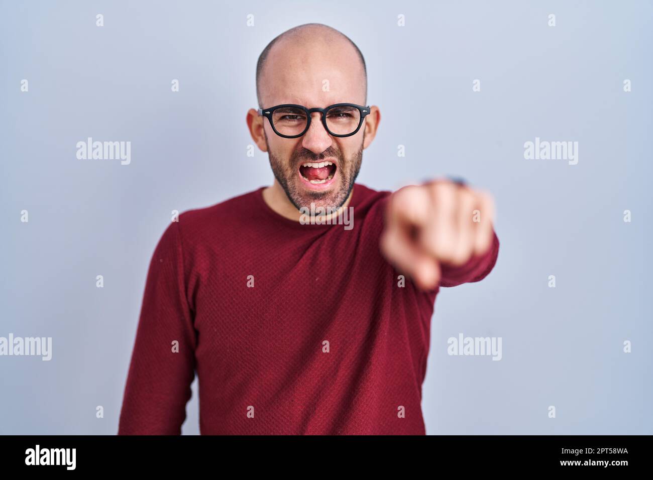 Young bald man with beard standing over white background wearing ...