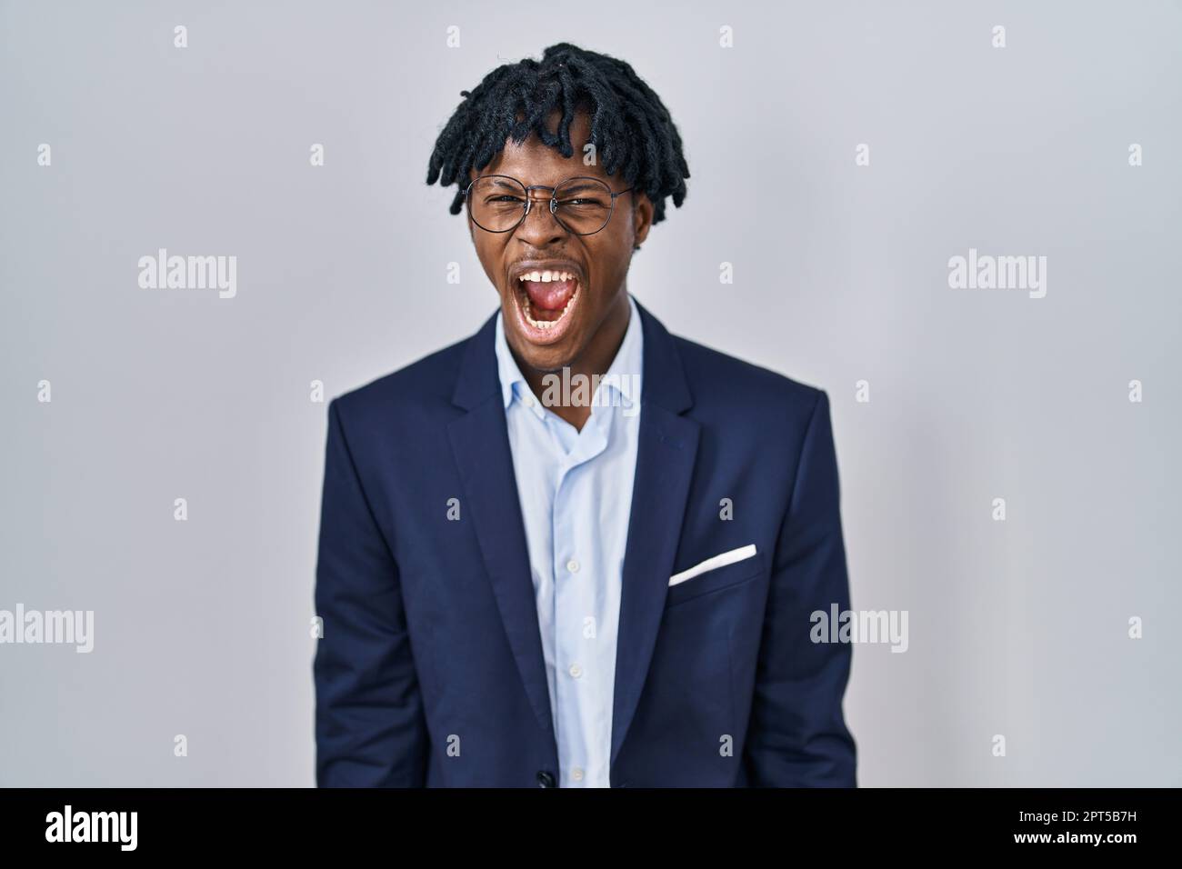Young african man with dreadlocks wearing business jacket over white ...