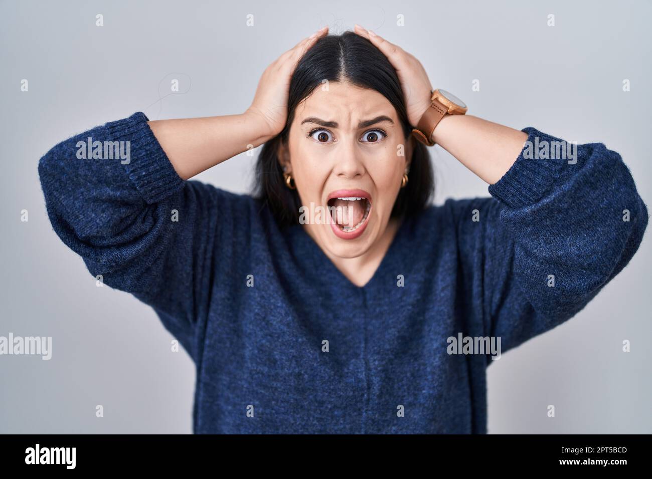 Young brunette woman standing over isolated background crazy and scared ...