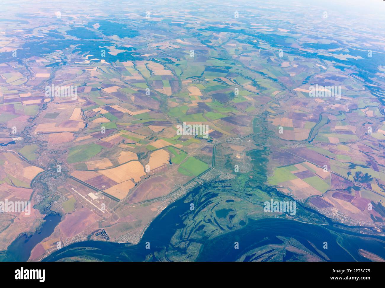 Aerial view from airplane window above green ground. View from the ...