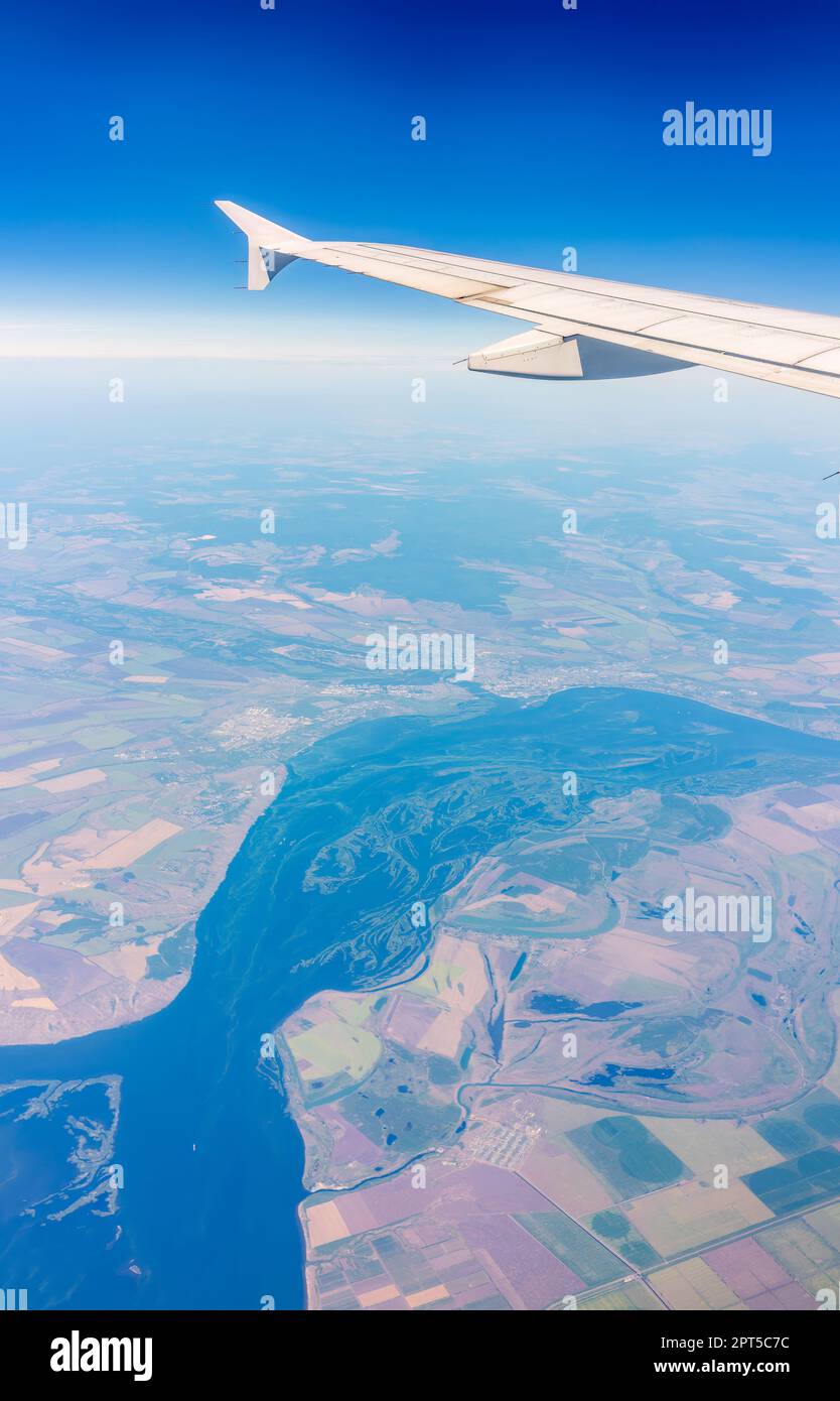 Aerial view from airplane window above green ground. View from the ...