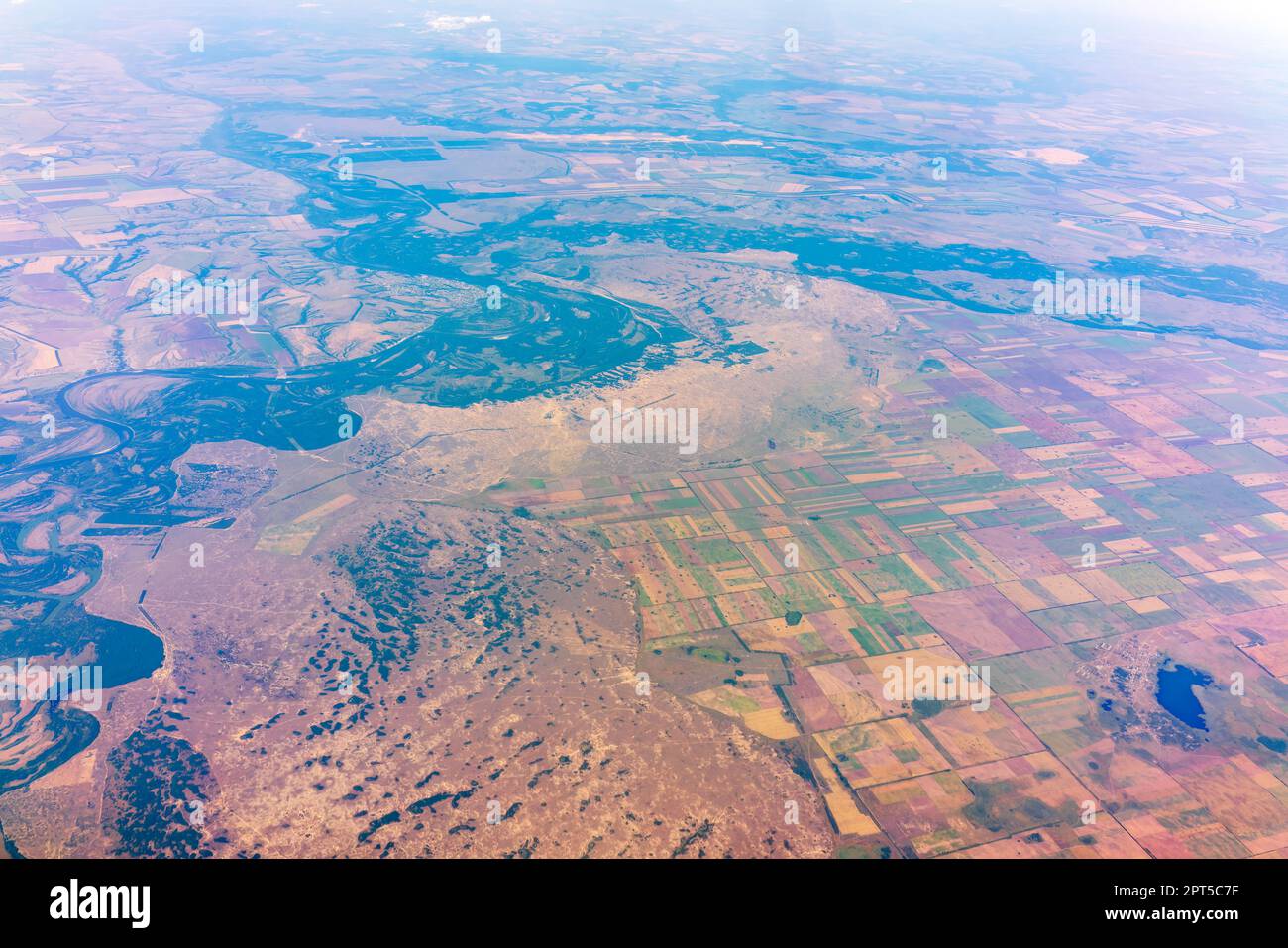 Aerial view from airplane window above green ground. View from the ...