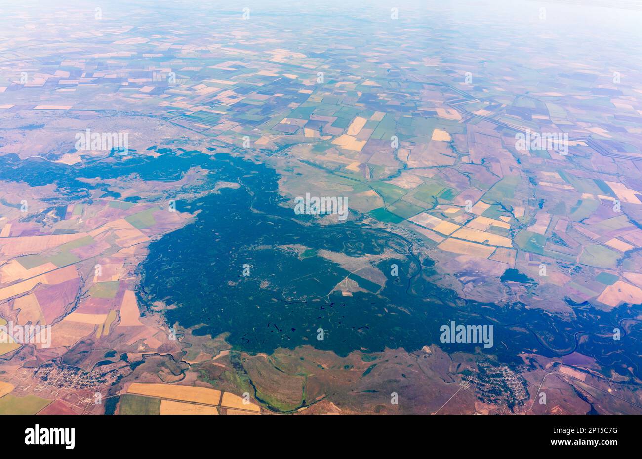Aerial view from airplane window above green ground. View from the ...