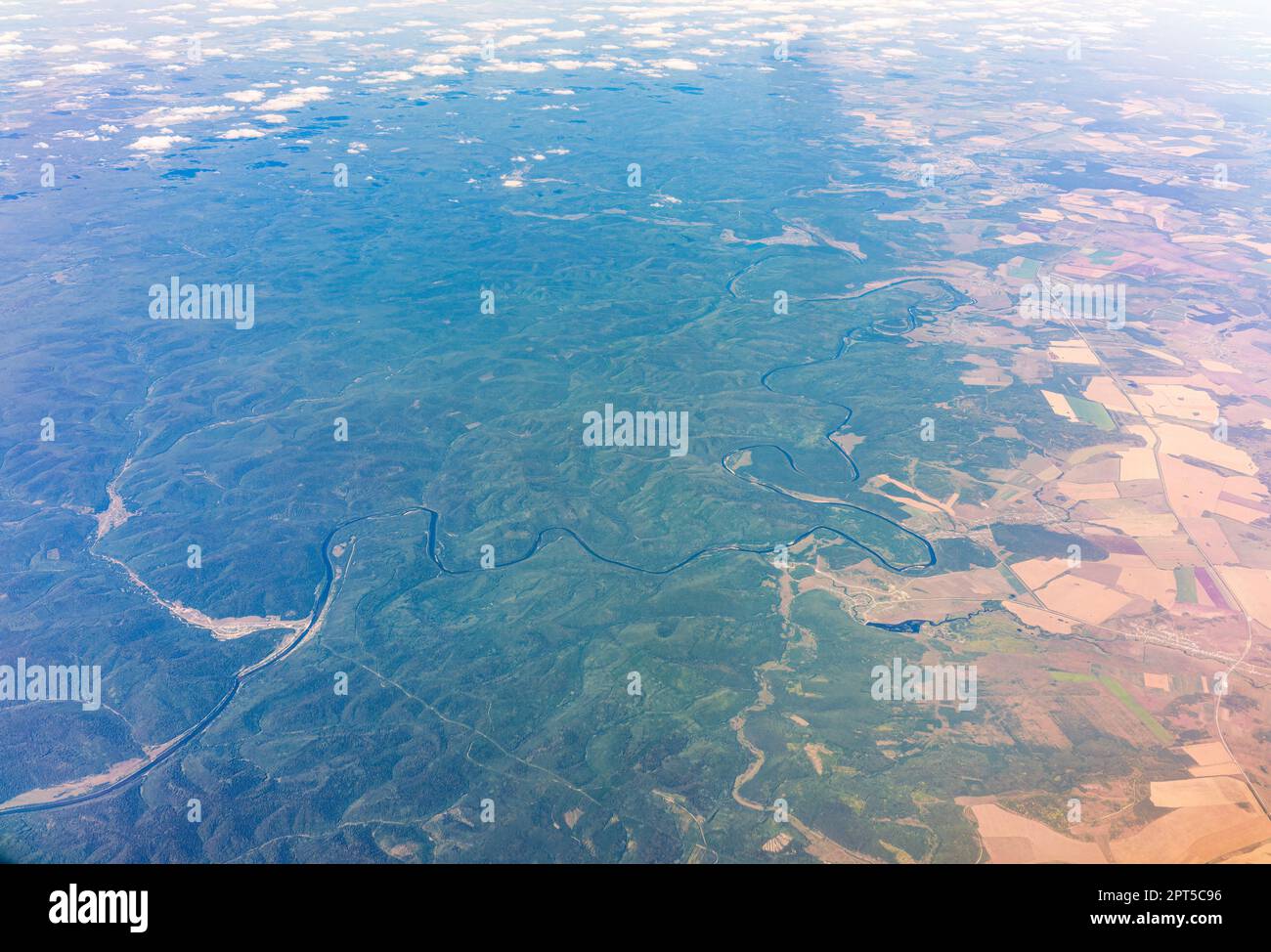 Aerial view from airplane window above green ground. View from the ...