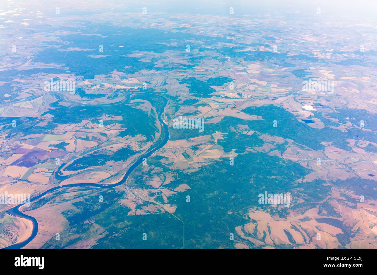 Aerial view from airplane window above green ground. View from the ...