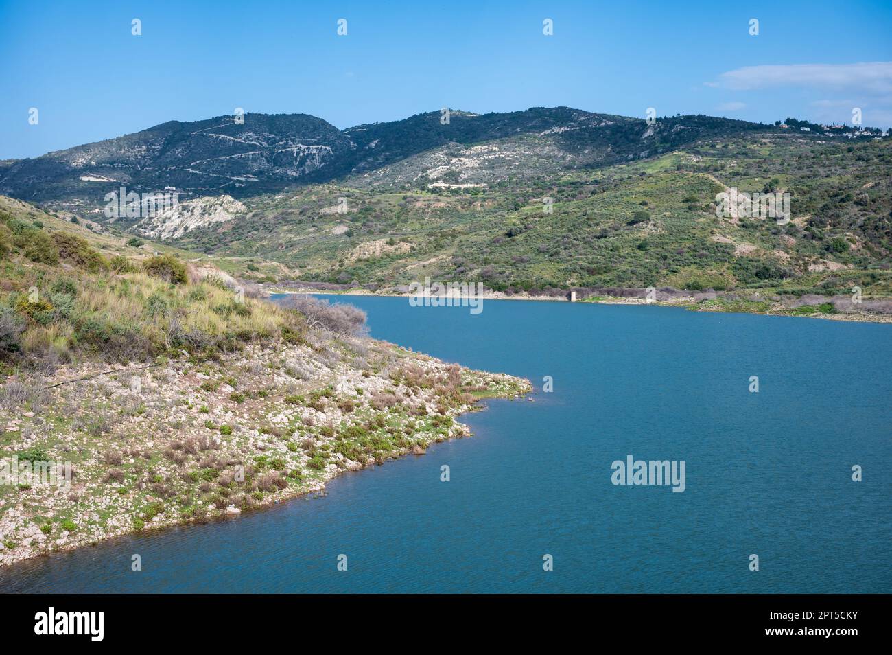 Green rocky hills and blue water of the Mavrokolympos reservoir in ...