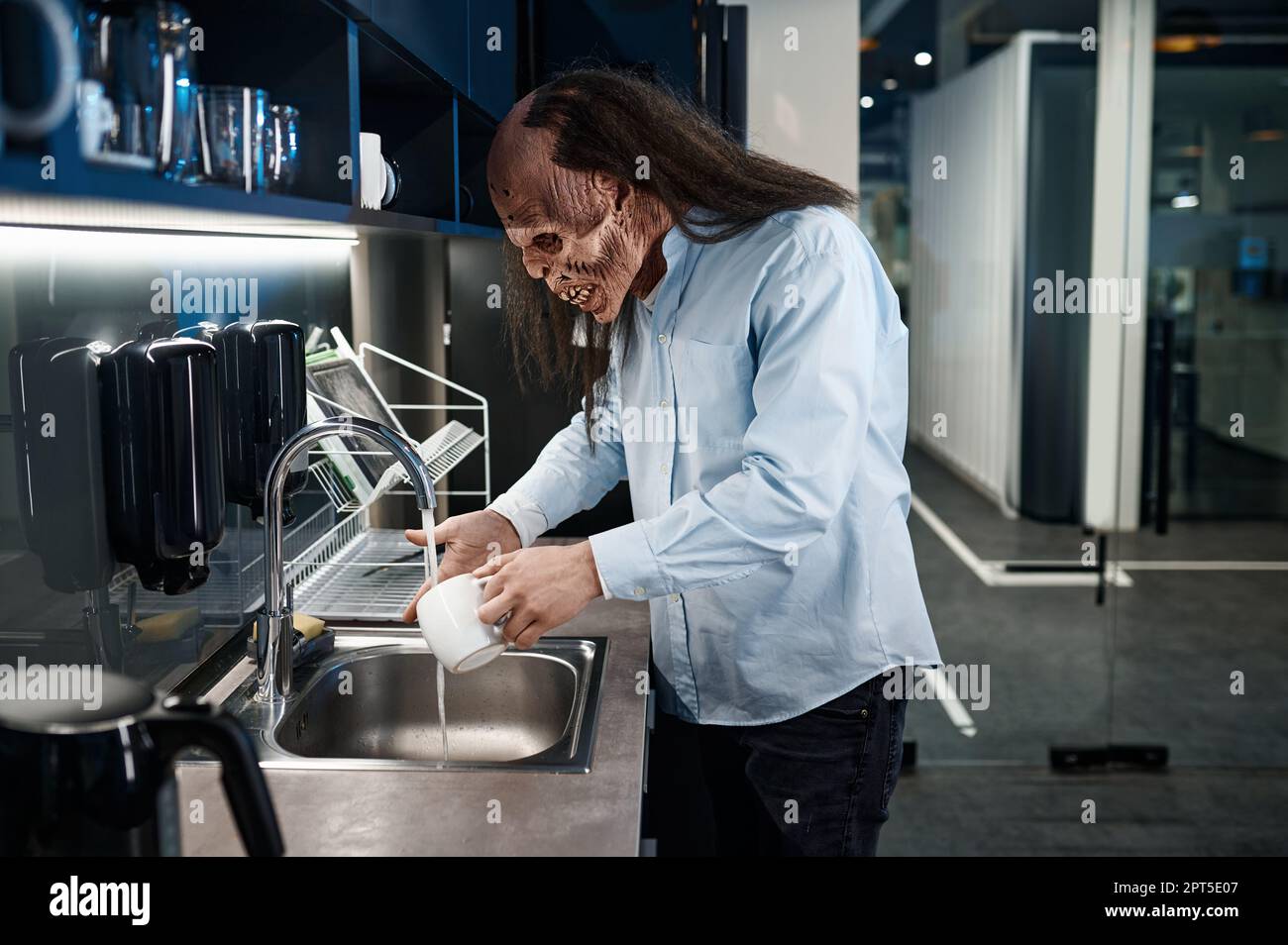 Creepy zombie employee washing cup in sink. Lunch time and coffee break ...