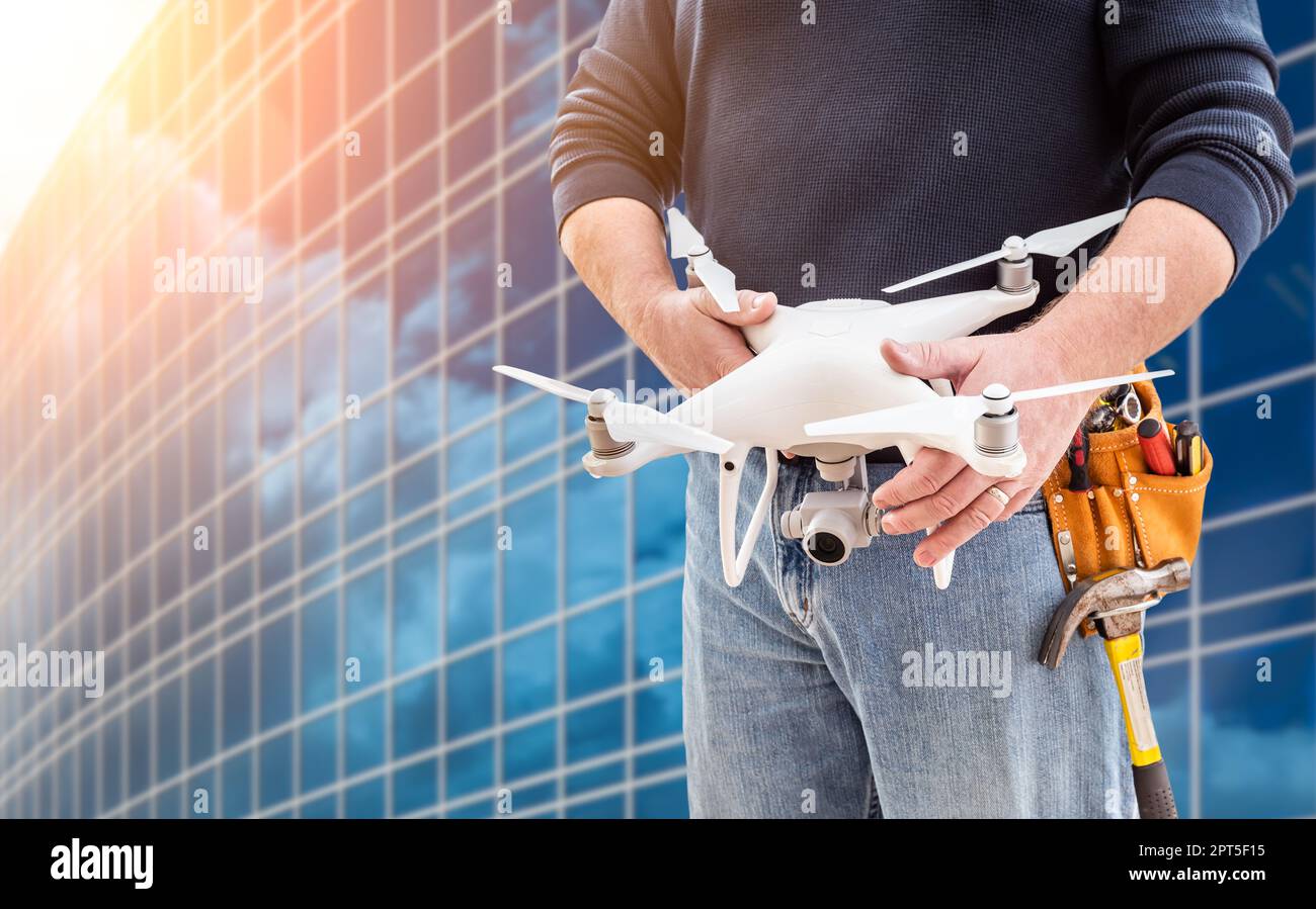 Construction Worker and Drone Pilot With Toolbelt Holding Drone At City ...