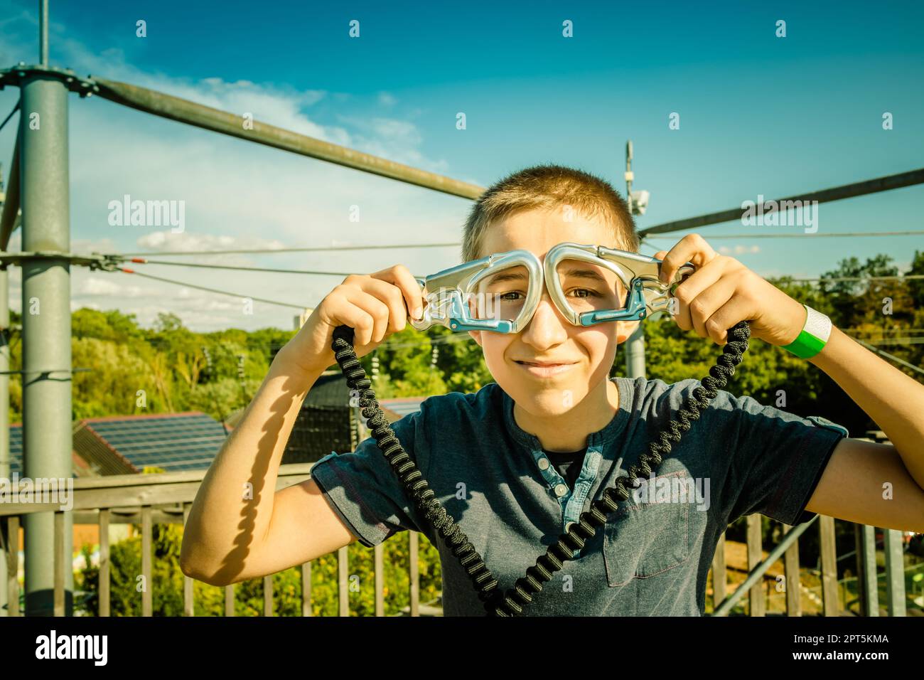 Zipline equipment for safety, adventure in high ropes course. Happy boy ...