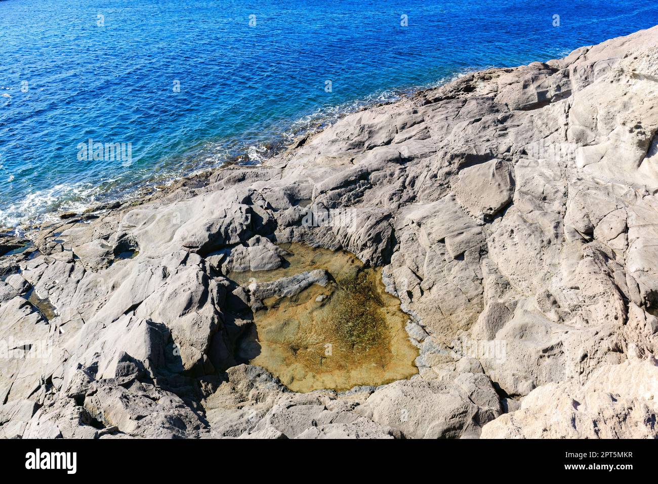 unusual rock formations of the volcanic cliff on Cala Sapone beach ...