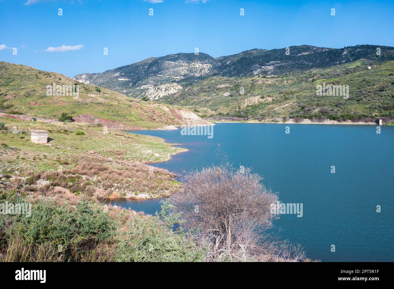Green rocky hills and blue water of the Mavrokolympos reservoir in ...
