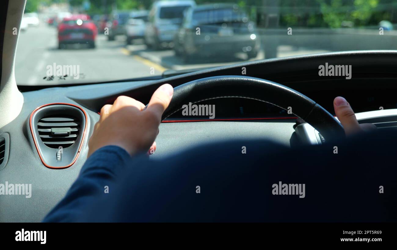 Male hands on steering wheel inside the car driving and looking at road ...