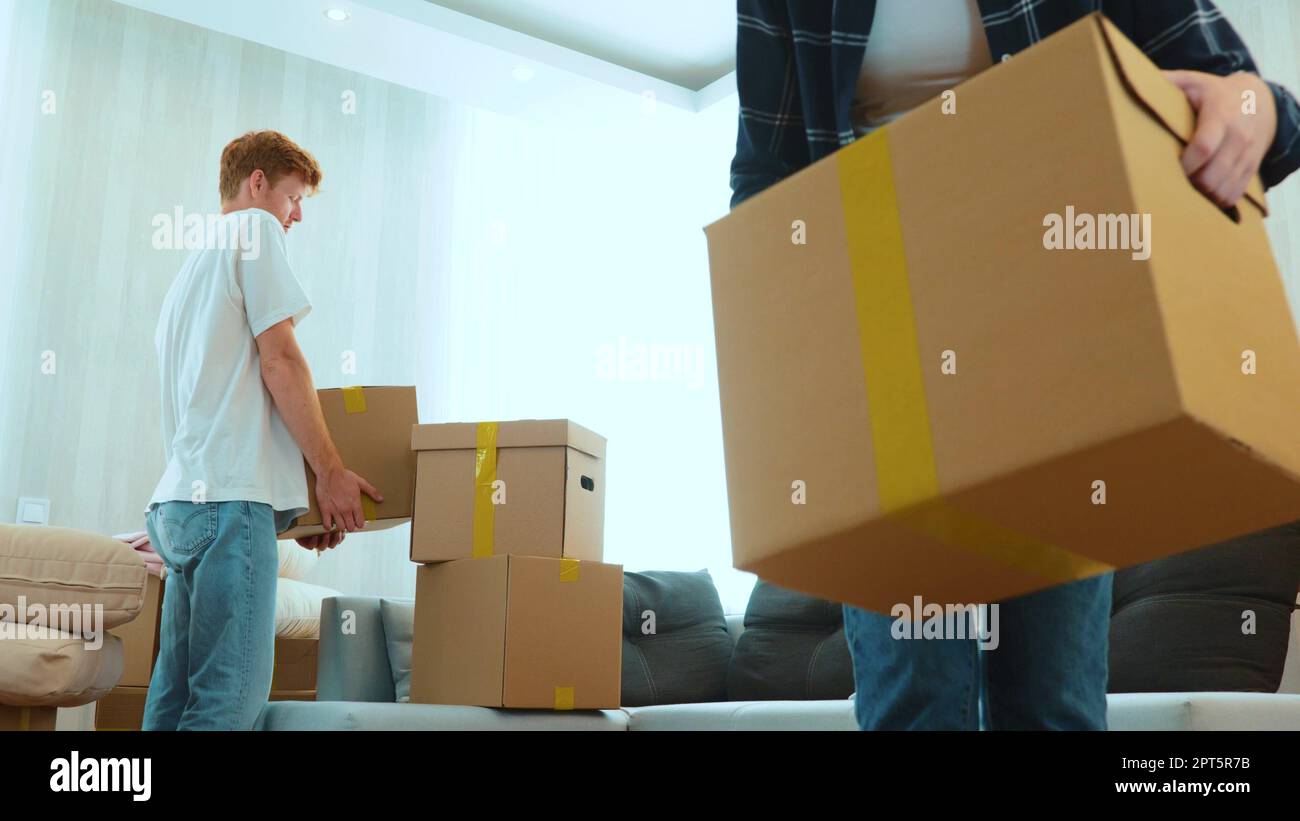Close up of positive young man and woman in room with many boxes ...