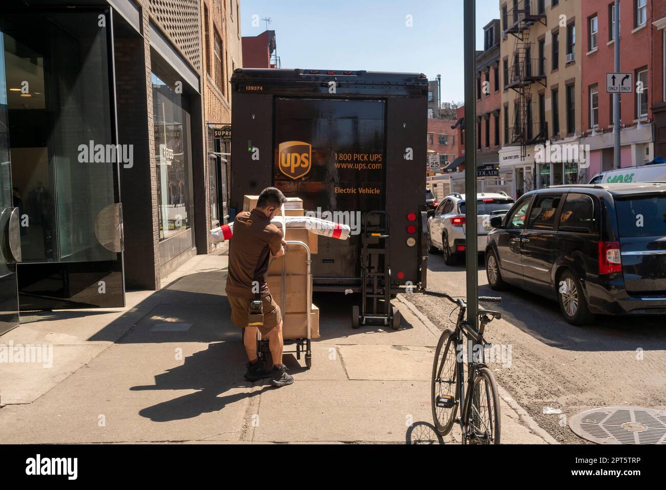 UPS worker with his cart laden with packages in Greenwich Village in ...