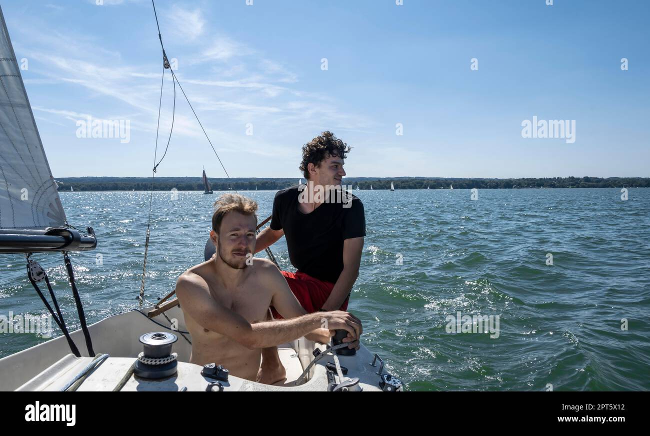 Two young men sailing on a sailboat, Lake Ammer, Bavaria, Germany Stock ...