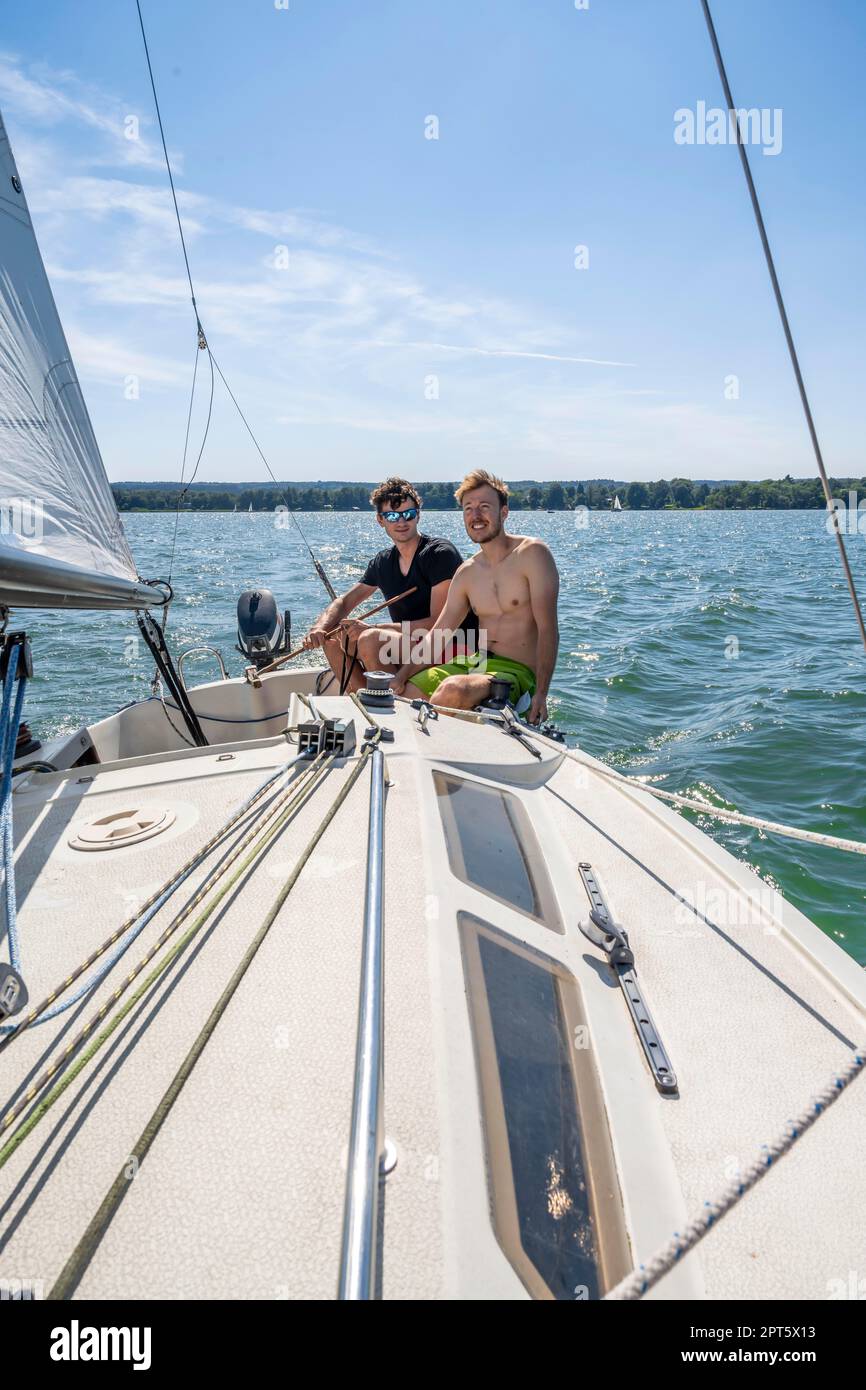 Two young men sailing on a sailboat, Lake Ammer, Bavaria, Germany Stock ...