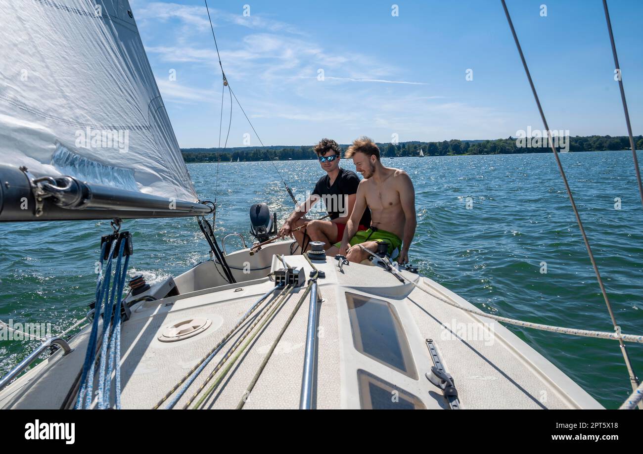 Two young men sailing on a sailboat, Lake Ammer, Bavaria, Germany Stock ...