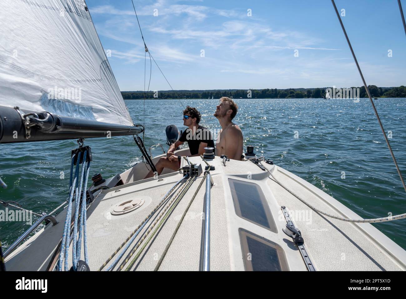Two young men sailing on a sailboat, Lake Ammer, Bavaria, Germany Stock ...