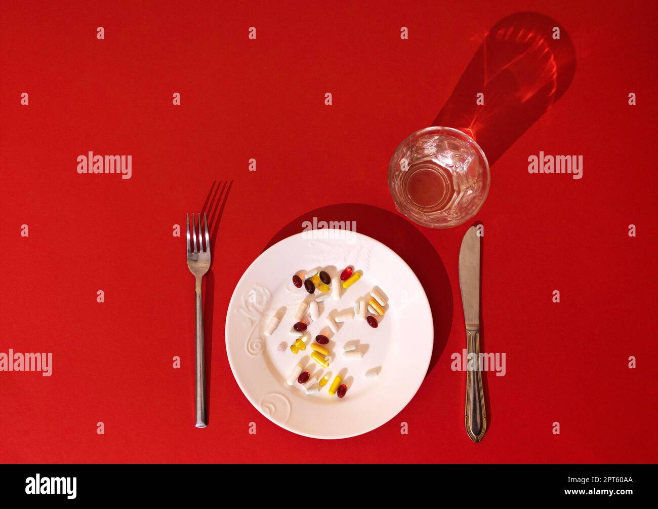 Tablets, pills and capsules on a white porcelain plate. The table is ...