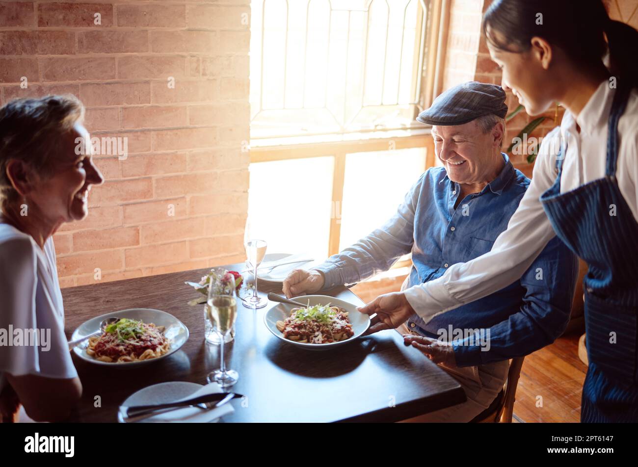 Happy senior couple at restaurant, waitress service with smile, and ...