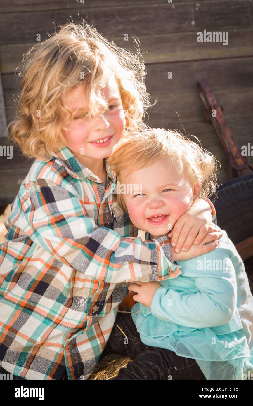 Sweet Little Boy Plays with His Baby Sister in a Rustic Ranch Setting ...