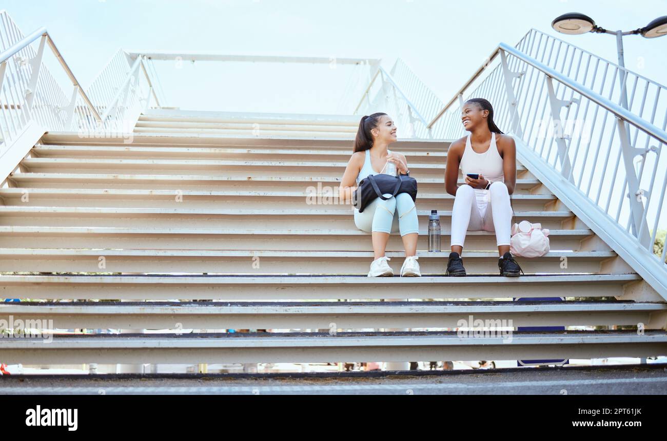 Friends, happy and relax after exercise on steps together, talking and ...