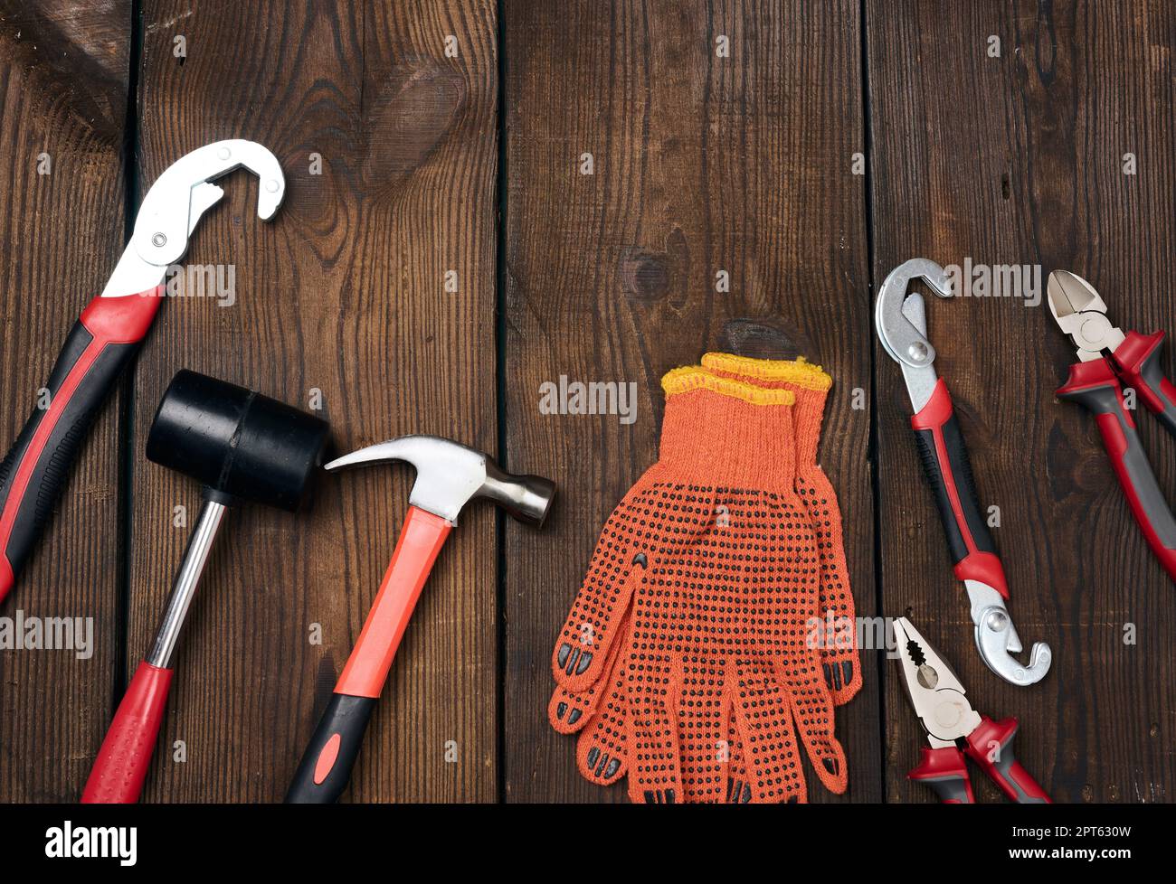 A set of construction tools on a brown wooden background, top view ...