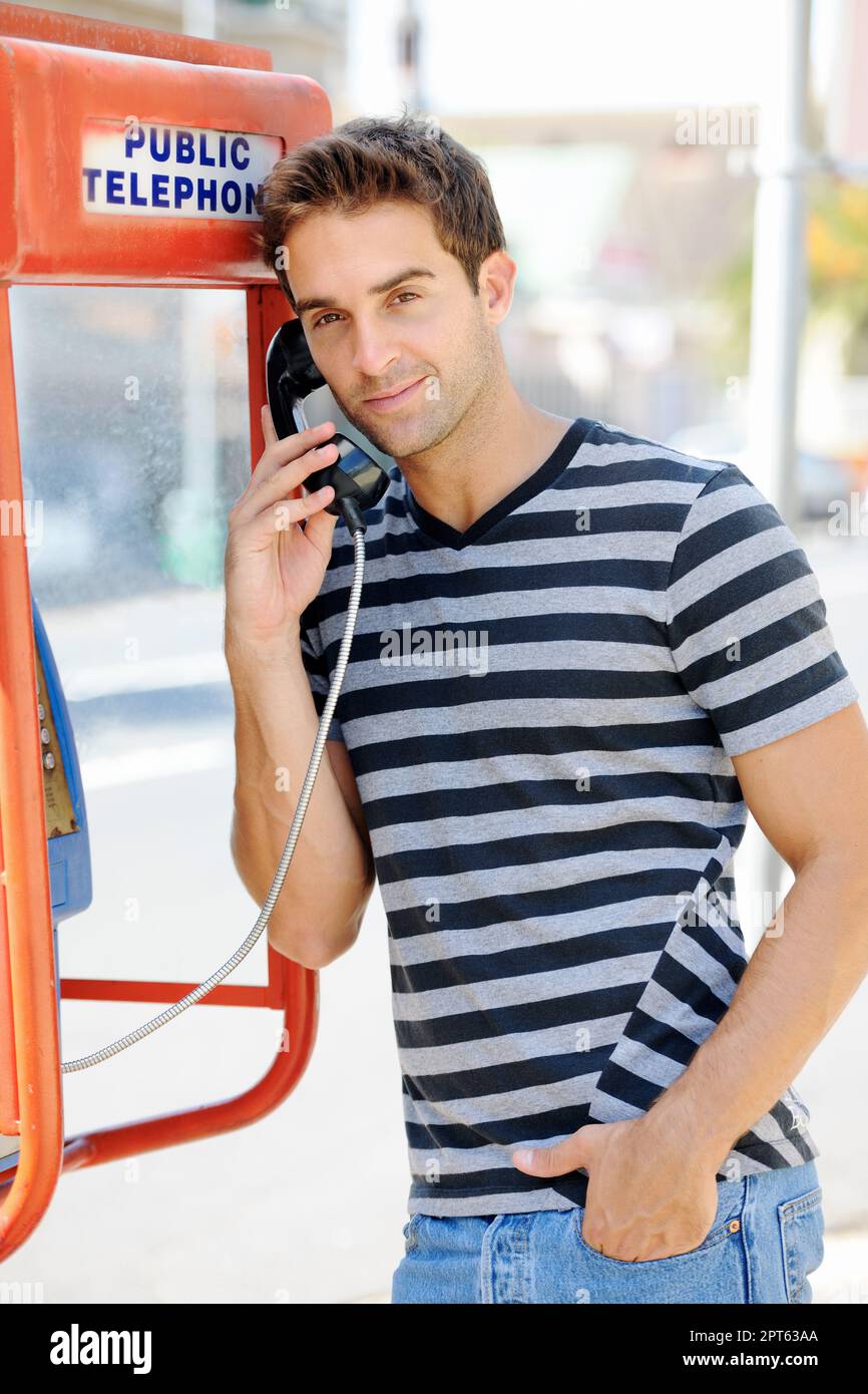 Cool and casual calling. A handsome young man standing casually with a ...