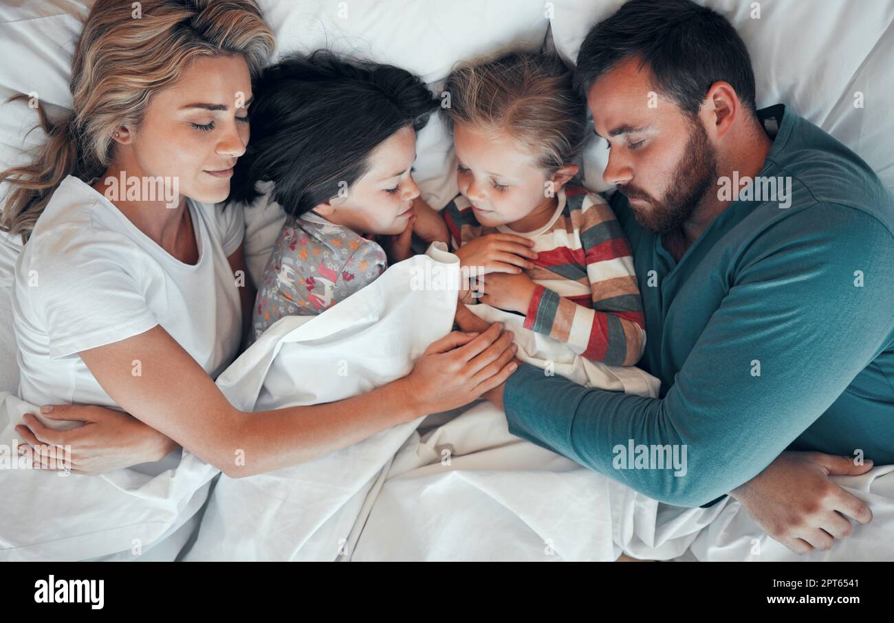 Sleeping caucasian family of four in pyjamas from above lying cosy ...