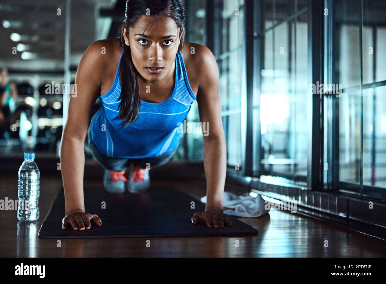 She lives strong. an attractive young woman doing pushups as part of ...