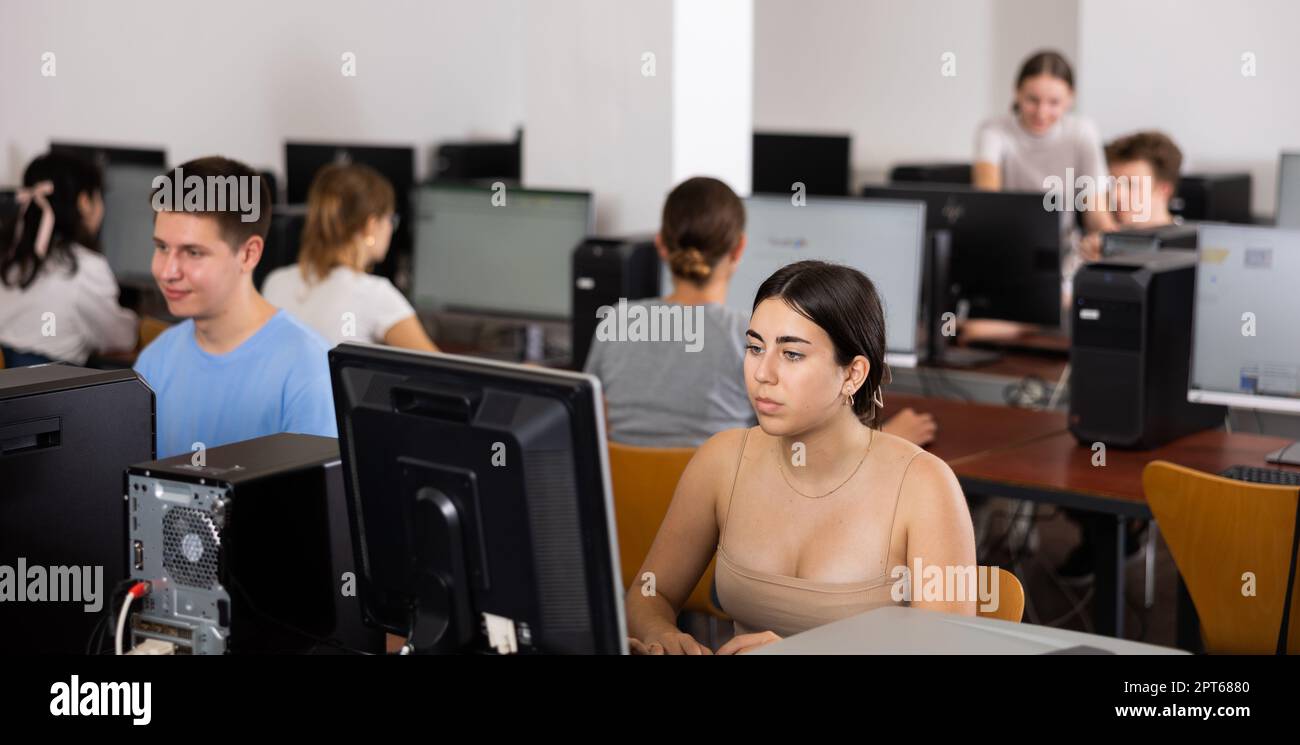 Portrait of interested teen girl during lesson in computer room of ...