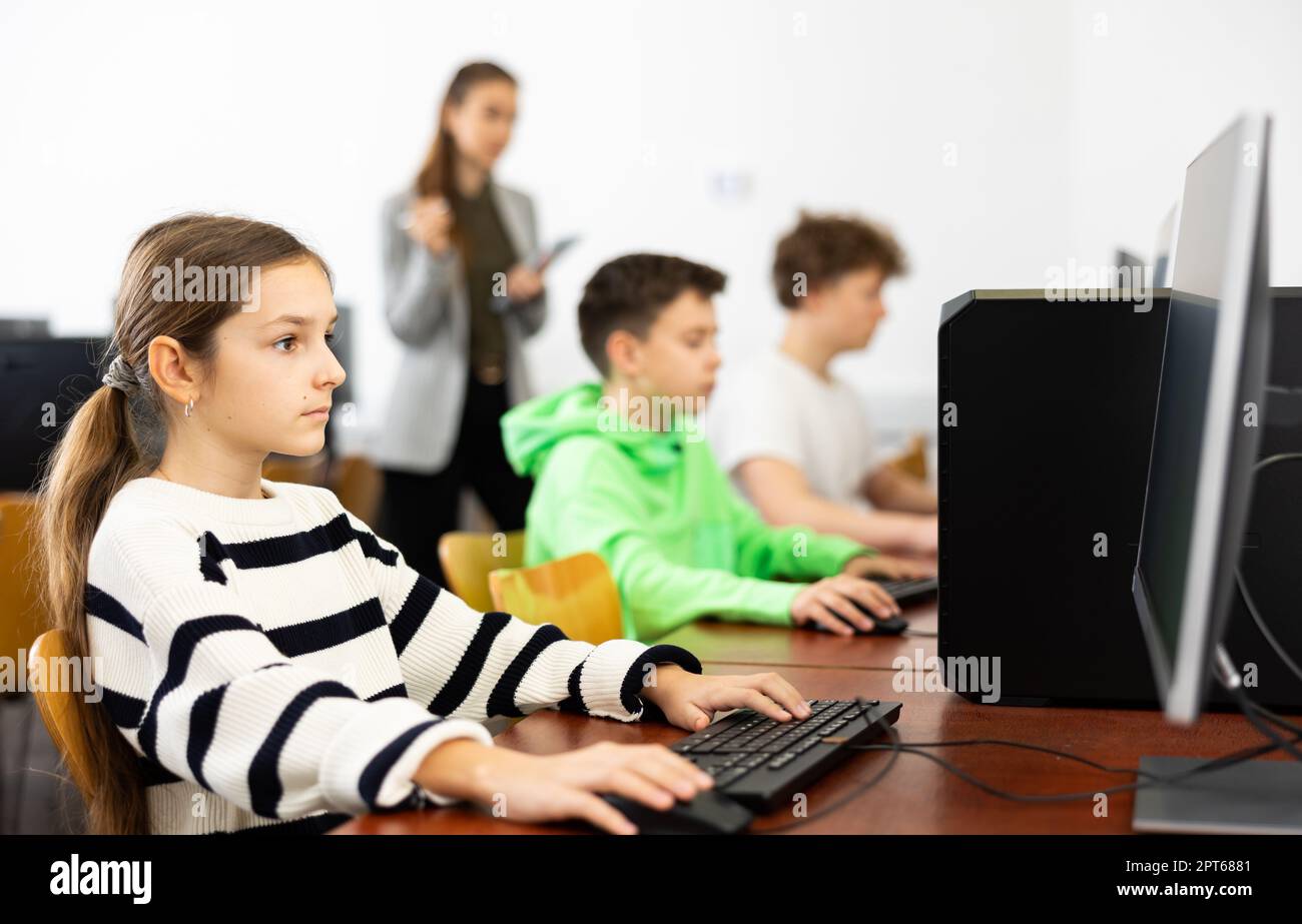 Young girl using computer during lesson Stock Photo - Alamy